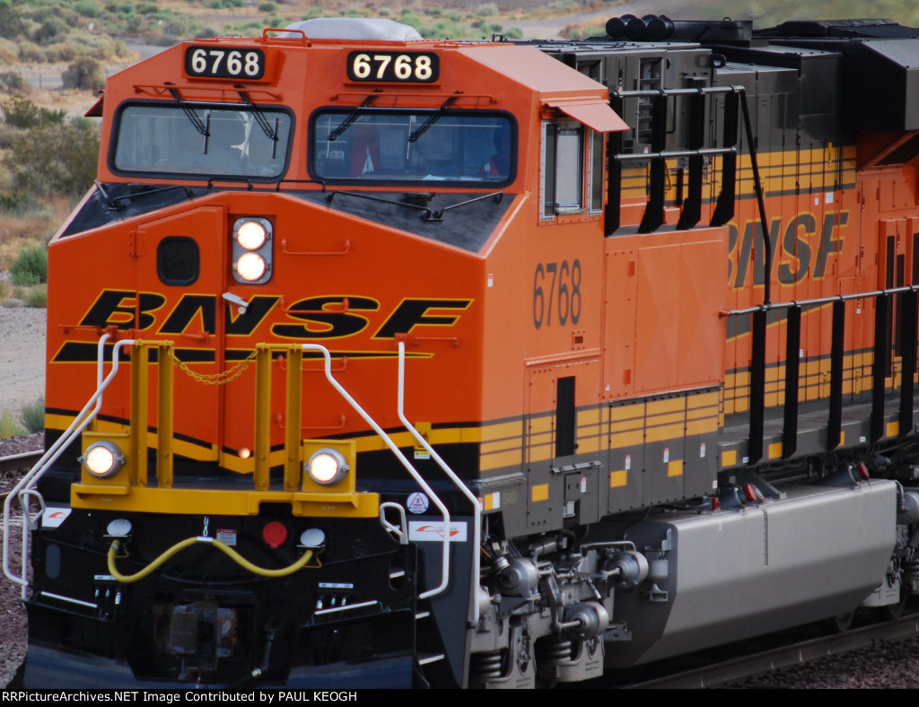 BNSF 6768 in the Cab shot as she rolls west leading a Empty Spi e car train called a Bear Table ...